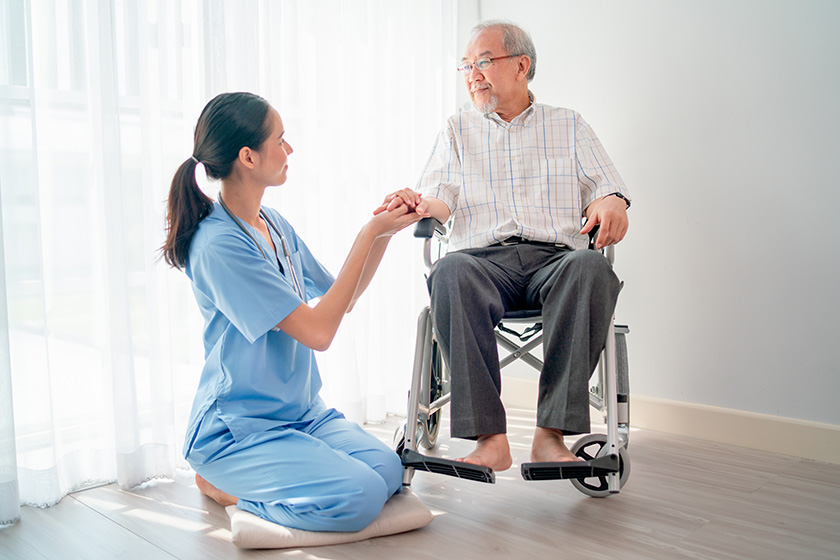 Asian nurse or doctor sit on floor and hold hands of senior man ...