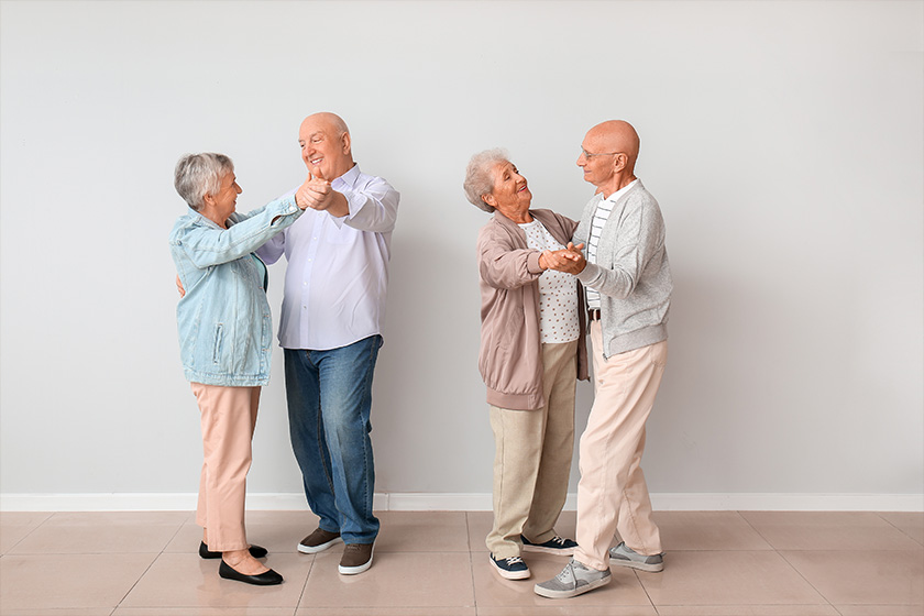Senior couples dancing near light wall | Morada Senior Living